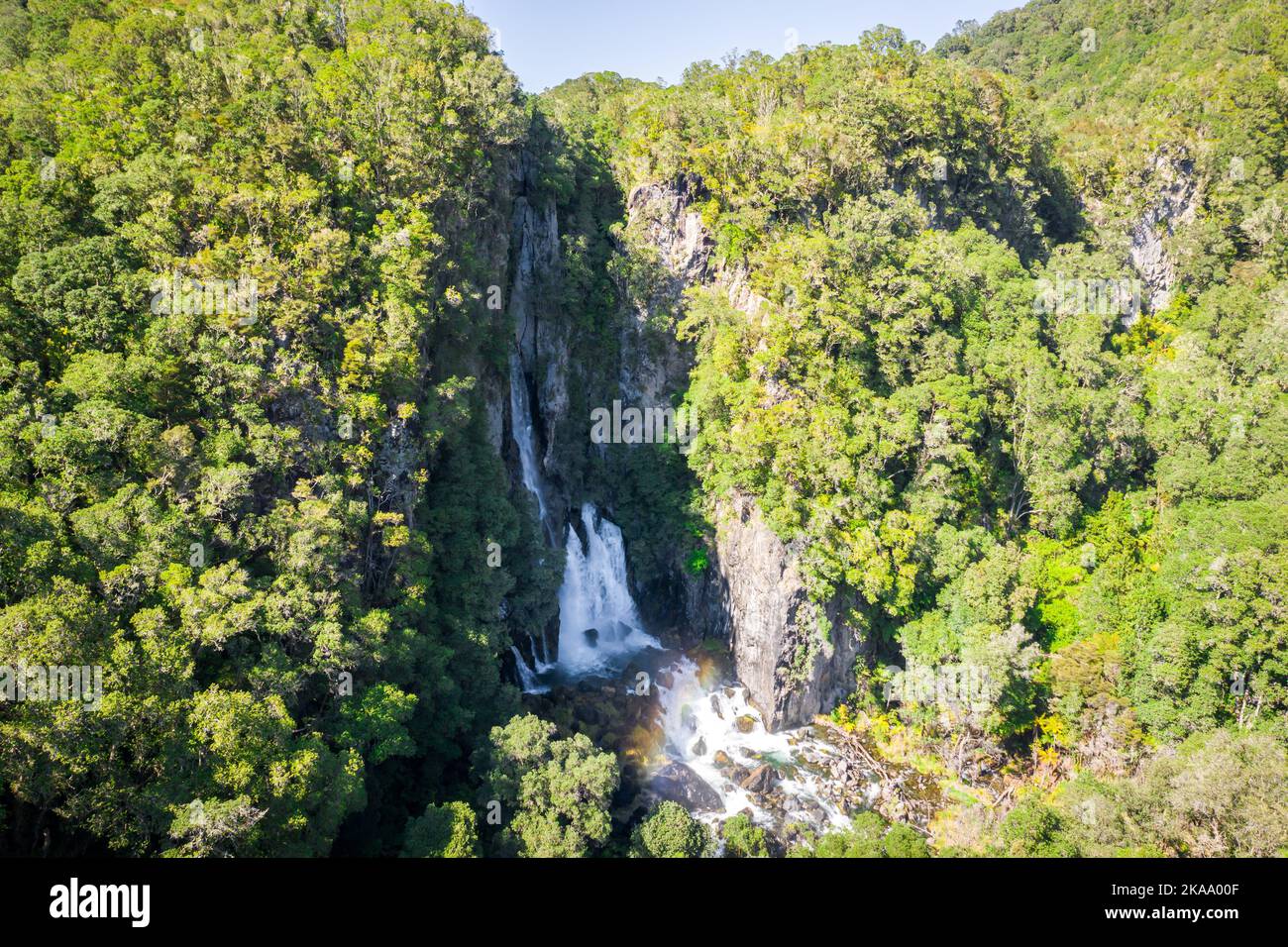 A bird's eye view of a waterfall flowing down the mountains covered ...