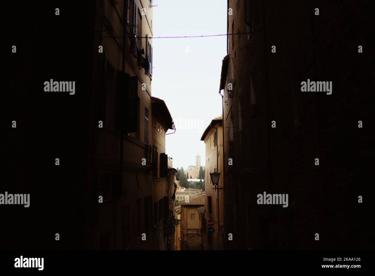 A closeup of a beautiful dark narrow alleyway between high buildings in ...