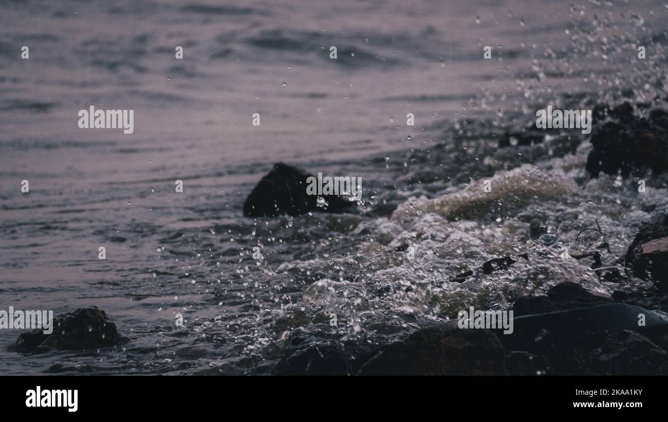 The waves crashing into the rocks making foam on a windy day Stock ...