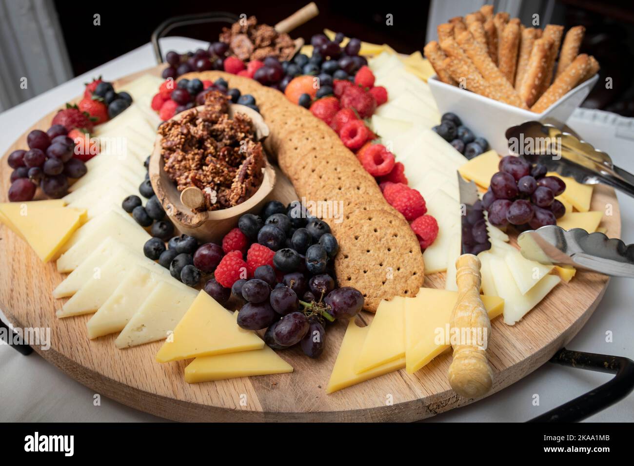 Various cheese, crackers, berries and nuts on a fine charcuterie board ...