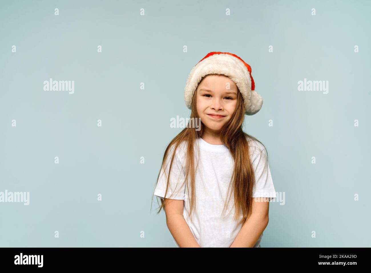 Funny cute baby girl in santa hat on blue background. Christmas and New ...