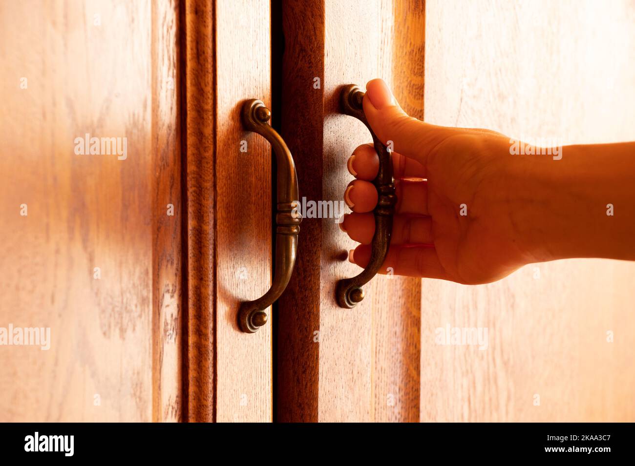 A woman's hand tears off an old wooden wardrobe, open the door of a ...