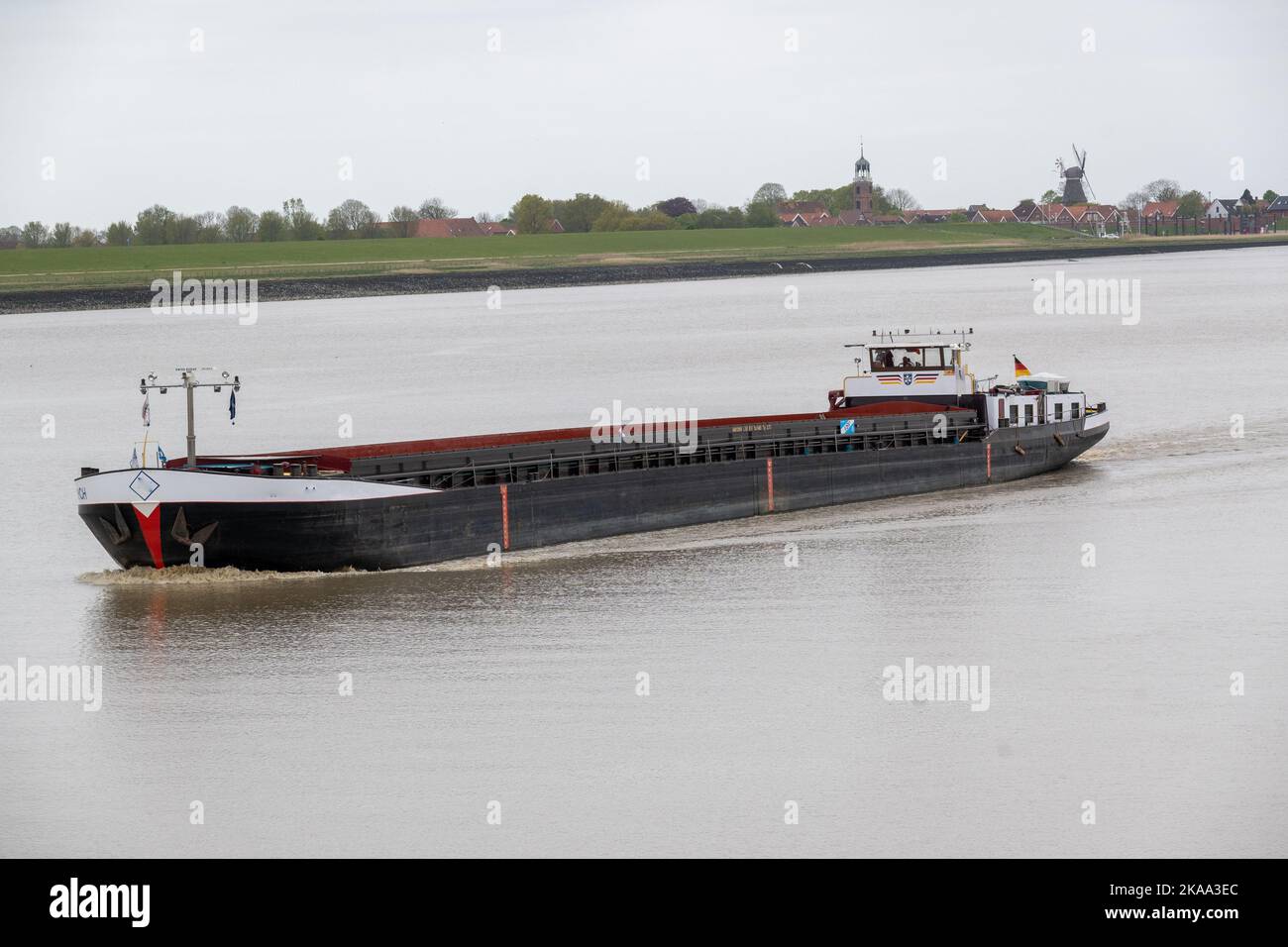 A big freight ship on the river Ems in Germany in clear sky background ...