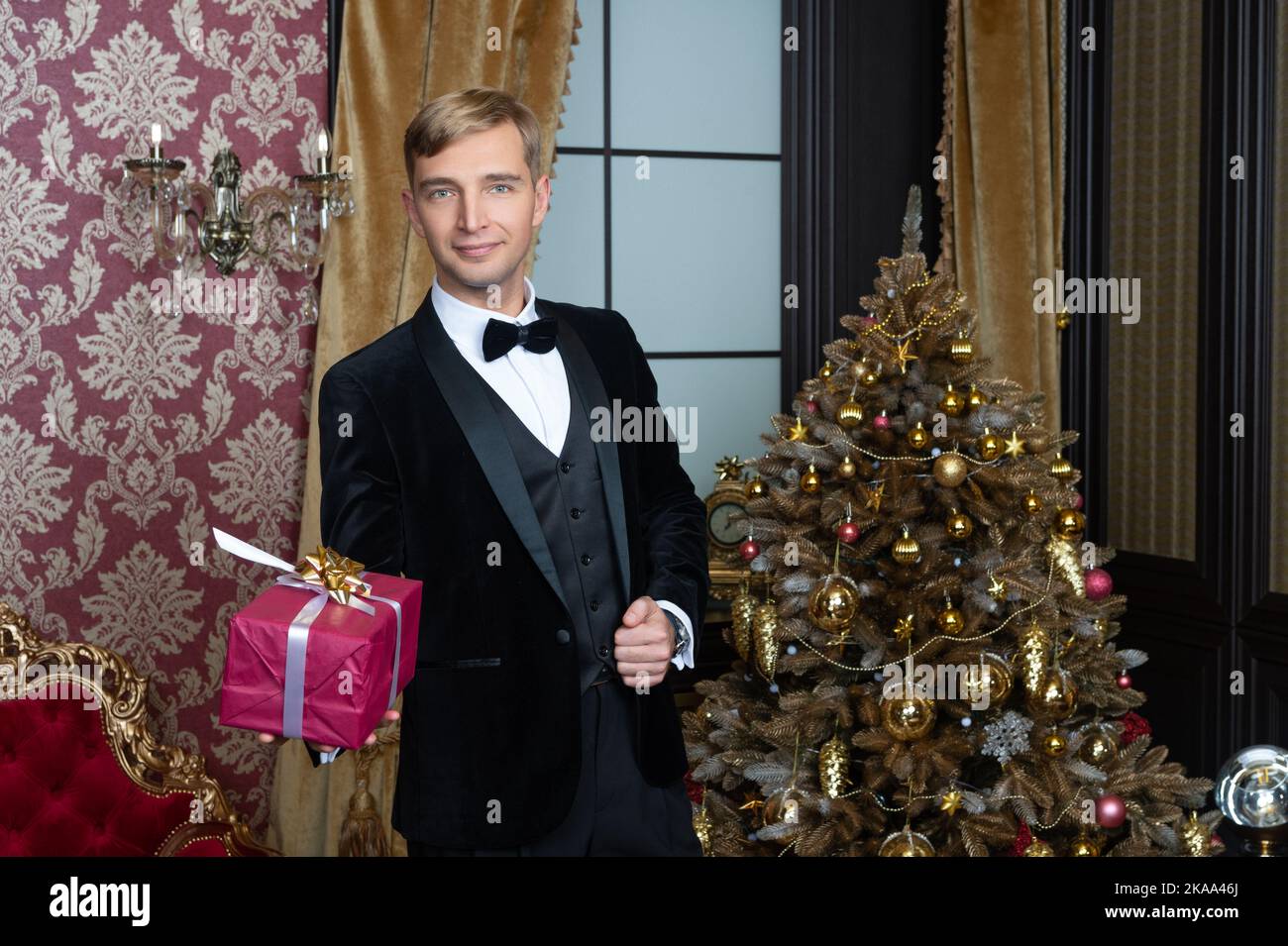smiling man celebrate christmas holiday. tuxedo man hold present box ...