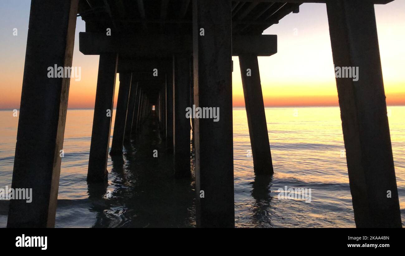 The structure under a pier during sunset Stock Photo - Alamy