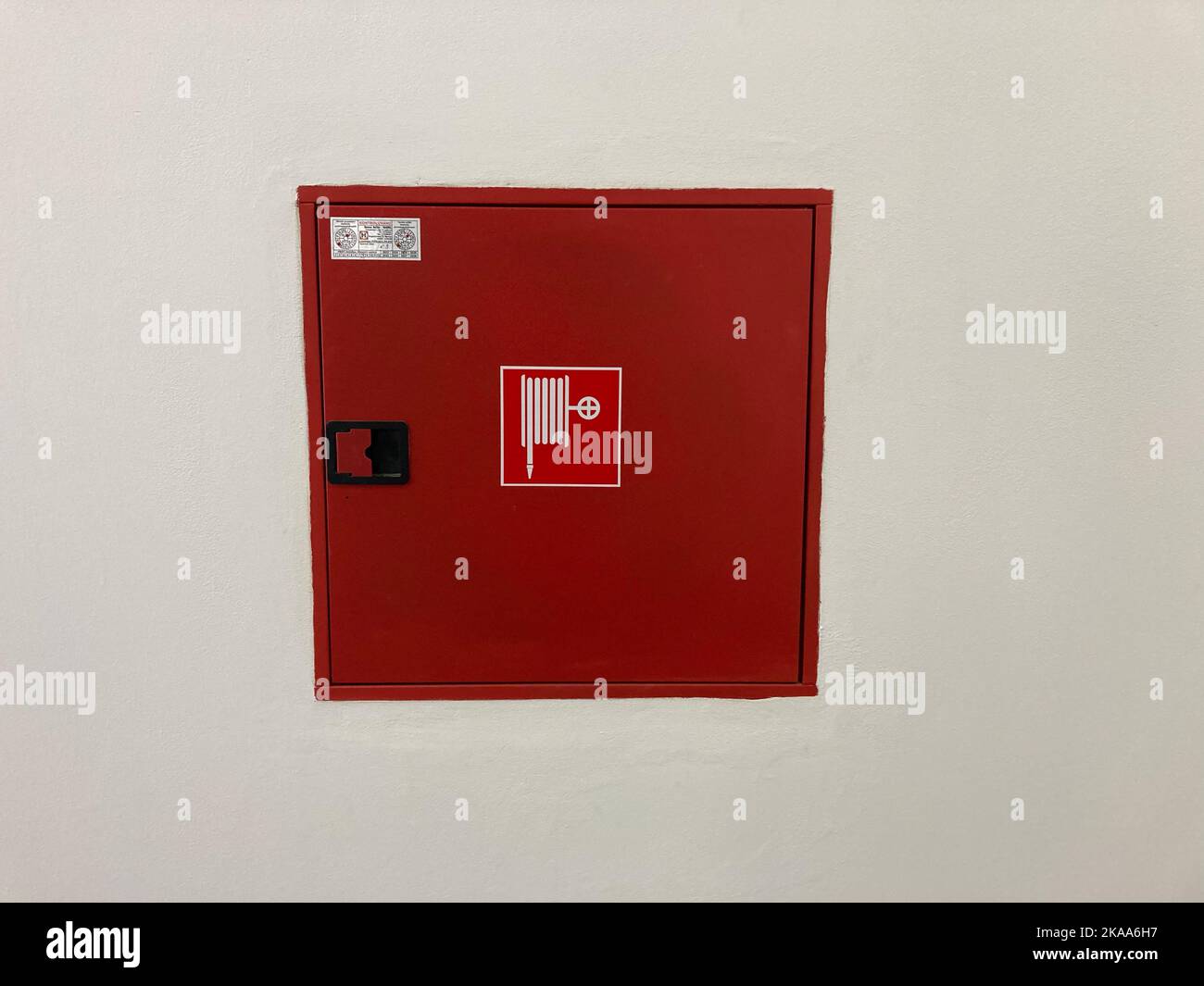 A fire hose box in the wall Stock Photo - Alamy