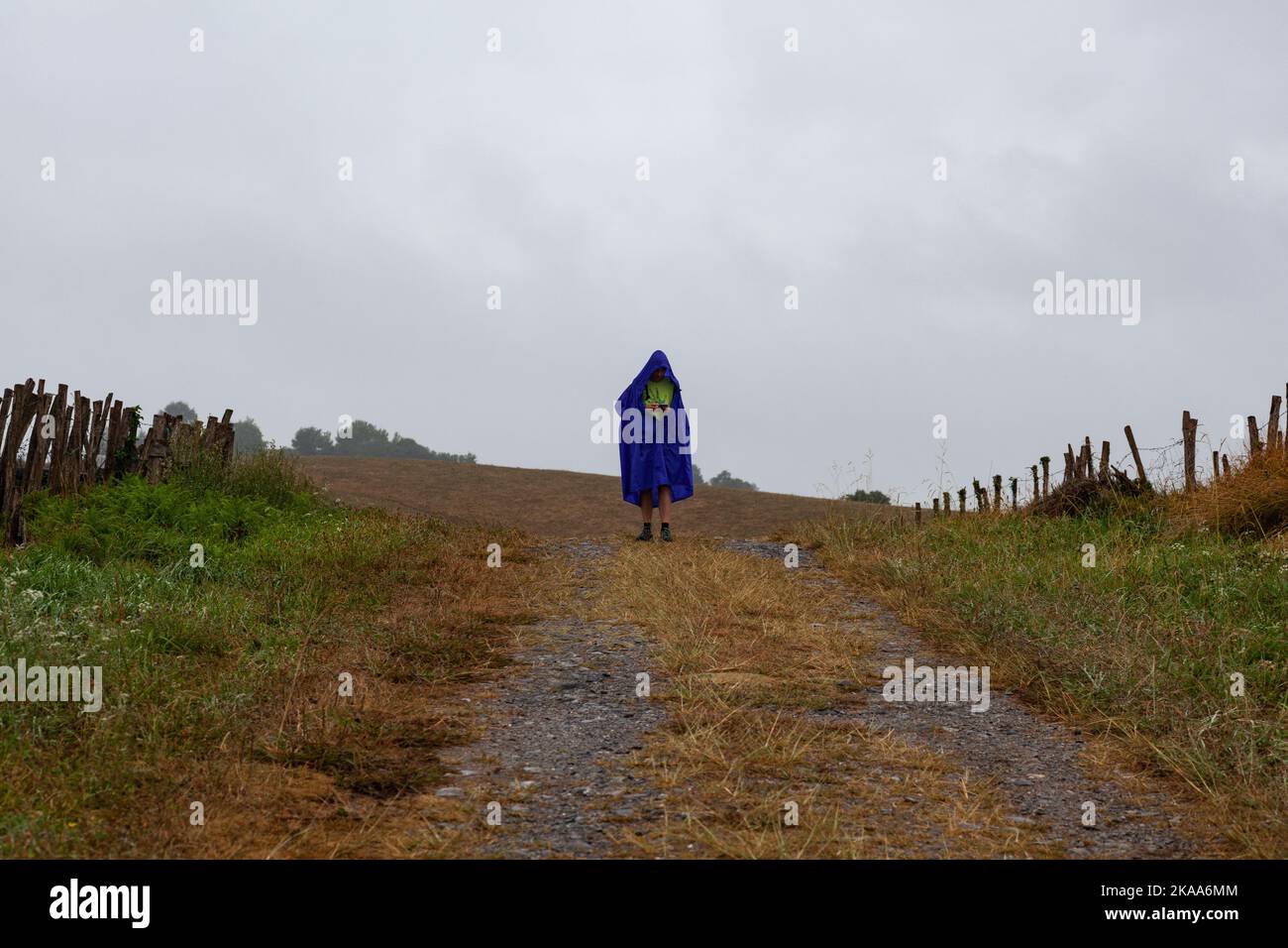 Pilgrim wearing a waterproof jacket check her smartphone during the ...