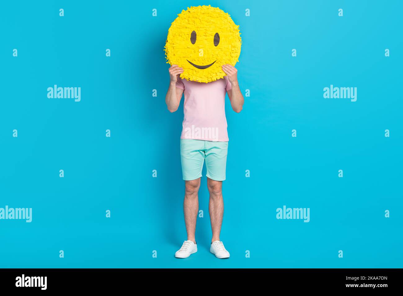 Full body photo of attractive young guy smile emoji pinata hide face ...