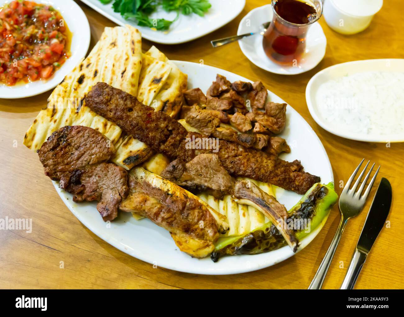 Turkish red meat plate served on dining table Stock Photo - Alamy