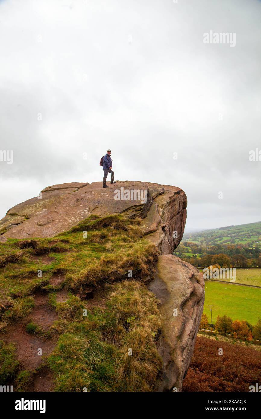 Man standing on the rock outcrop the Hanging Stone in the Cheshire ...