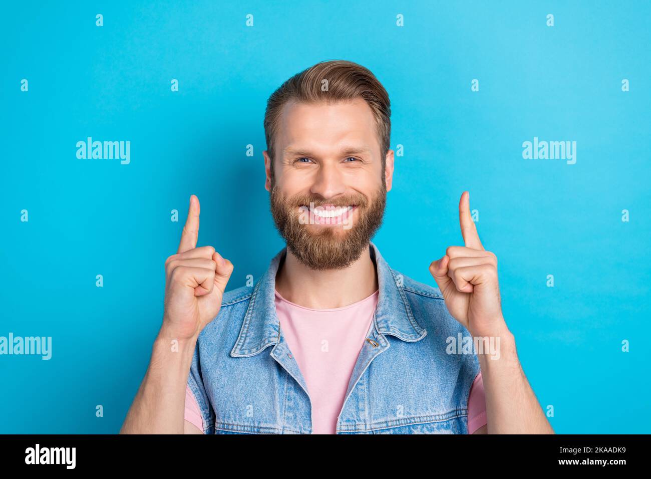 Photo of cheerful excited young guy dressed denim vest pointing two ...