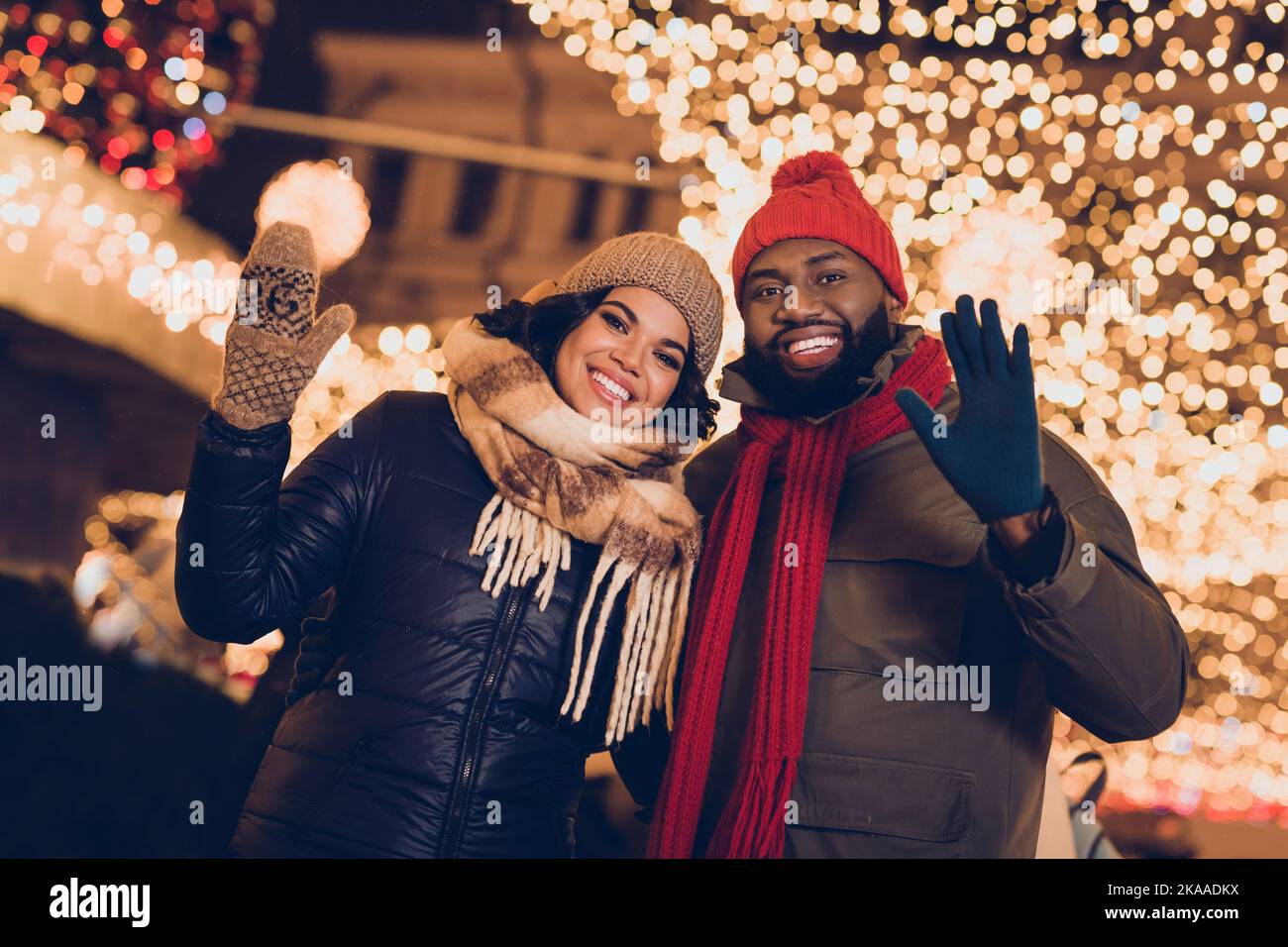 Portrait of attractive cheerful couple wife husband waving hi hello ...
