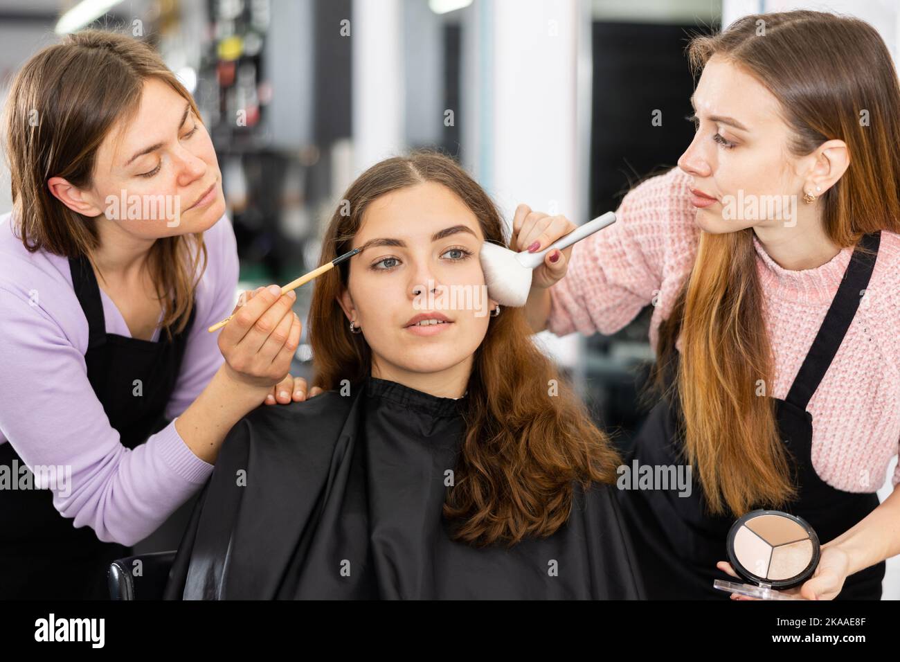 Two female makeup artists working with young girl client Stock Photo ...