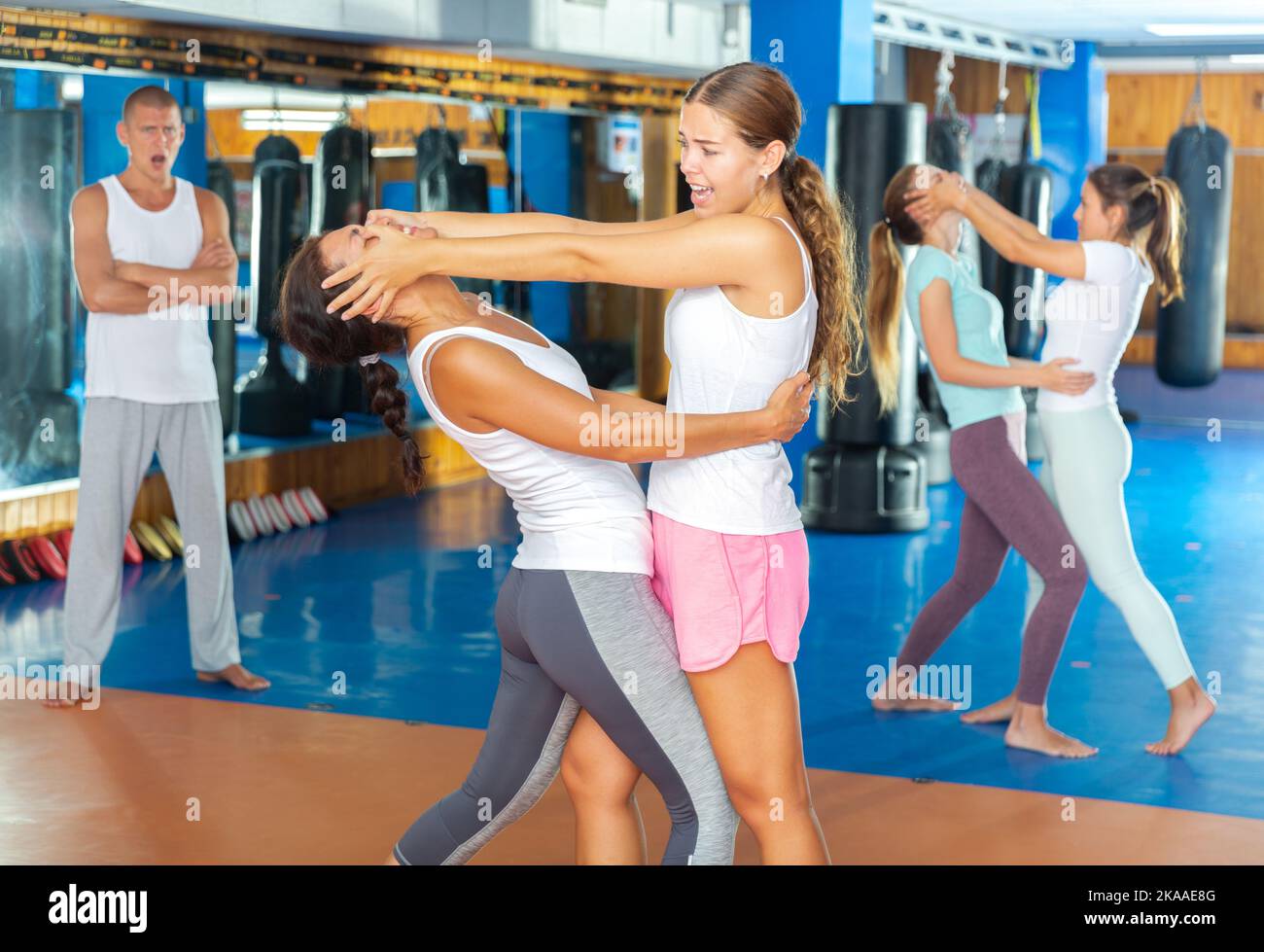 Young woman attacking eyes of female partner during self-defense ...