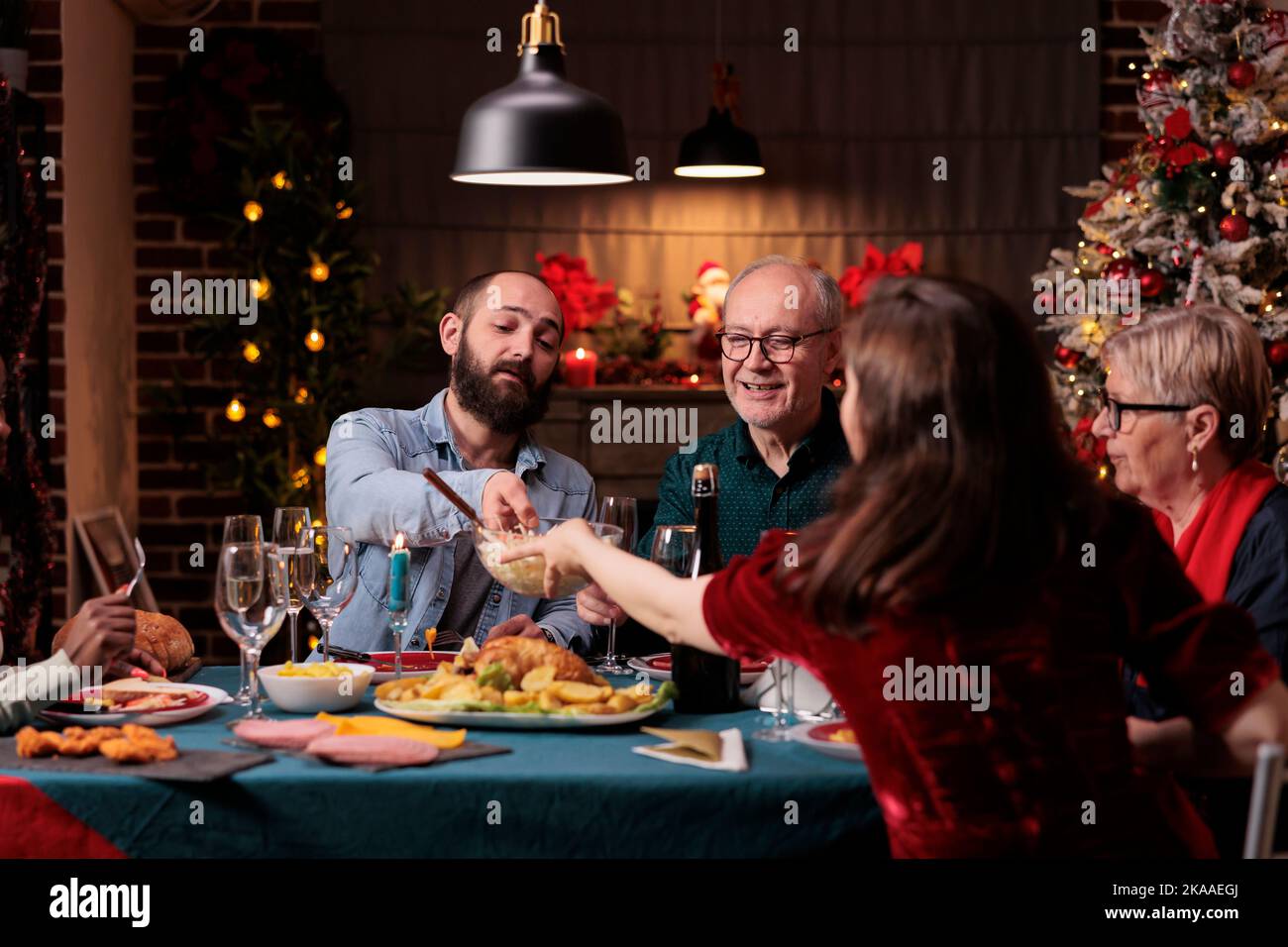 Happy family celebrating christmas, chatting, eating dishes at festive ...
