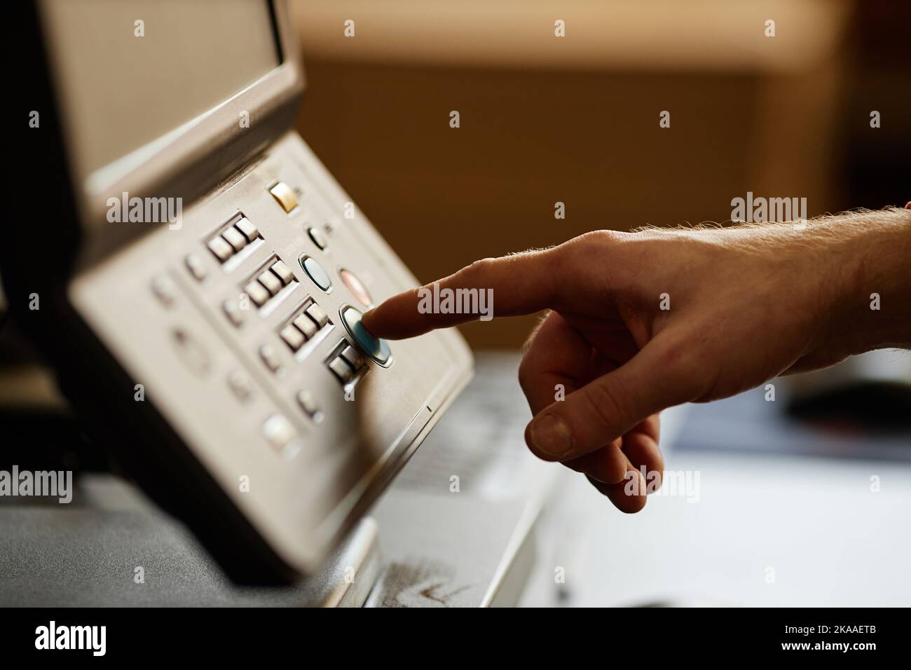 Side view close up of male hand pressing start button on printing ...