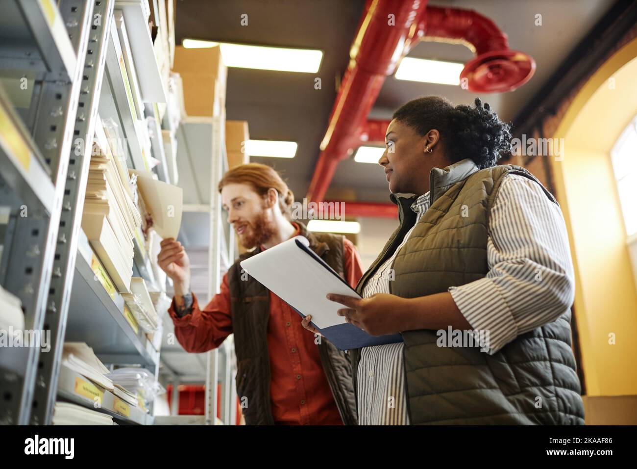 Low angle view at two workers taking stock of production at print ...