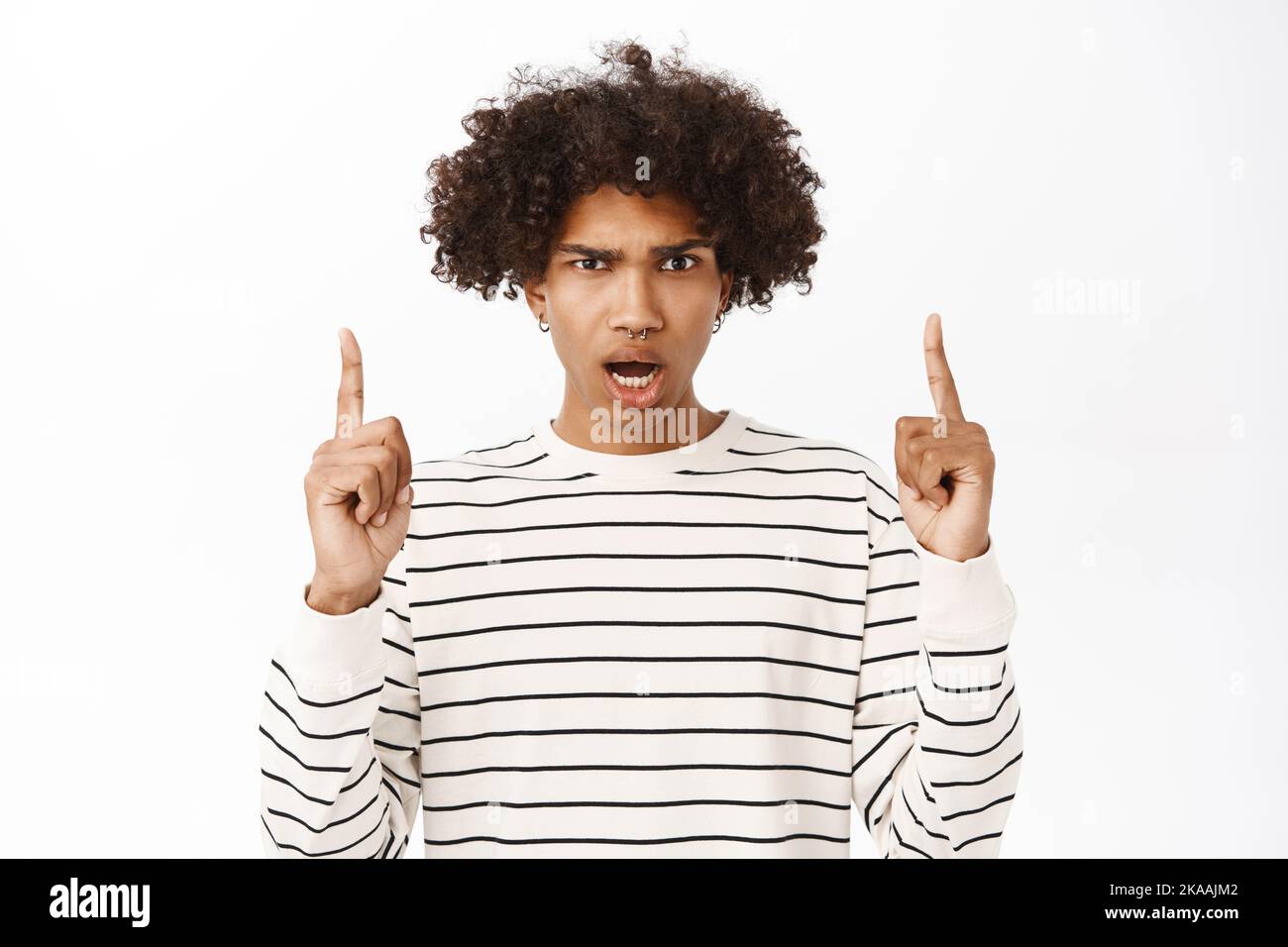 Offended hispanic guy, frowning upset, pointing fingers up, showing ...