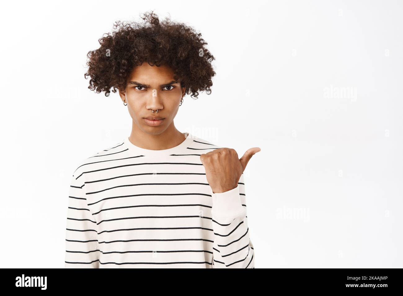 Angry hispanic teen boy pointing finger right, showing banner and ...