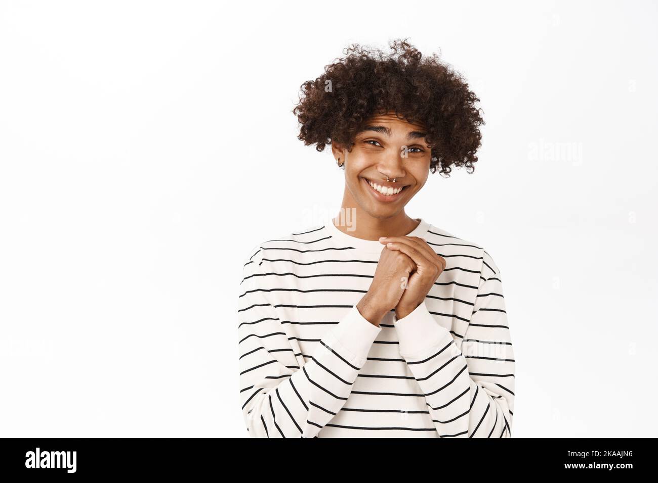 Close up portrait of cute hispanic guy, holding hands together, looking ...