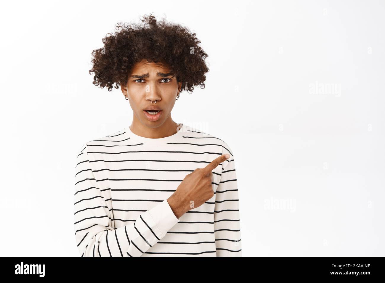 Close up portrait of confused hispanic boy pointing finger right at ...
