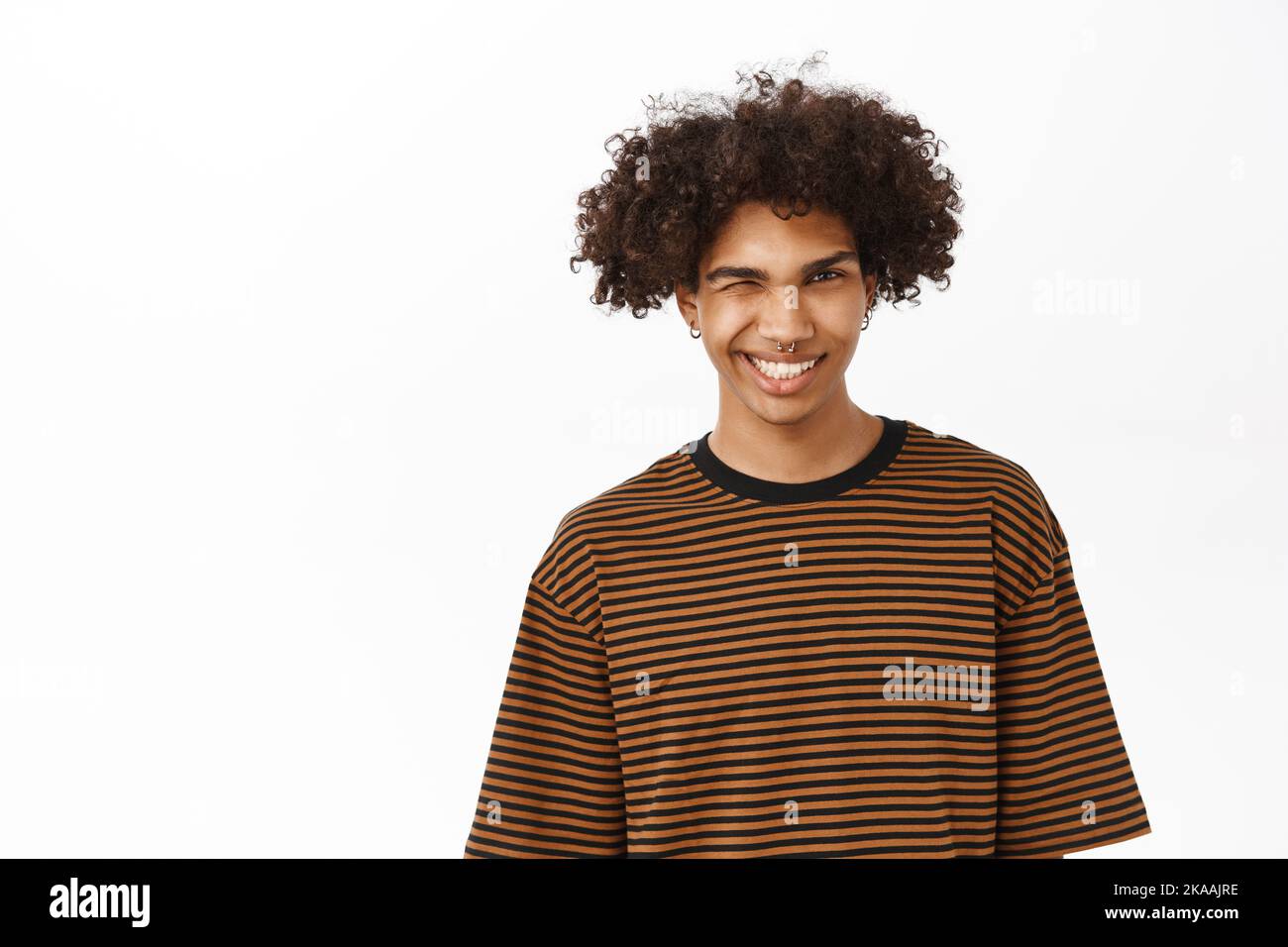 Close up of smiling hispanic guy with curly hair, looking happy and ...