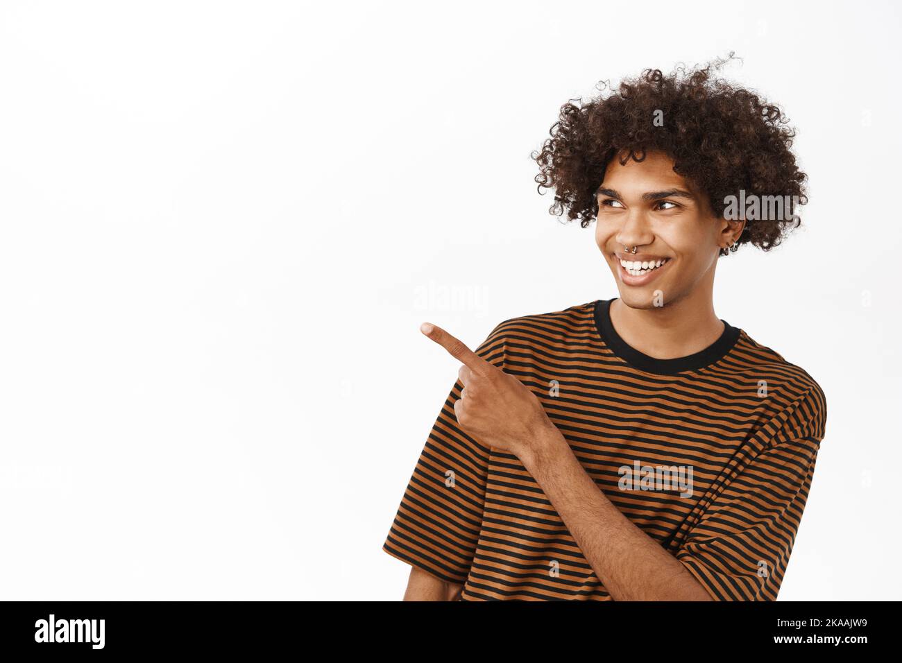 Handsome hispanic guy pointing left and smiling, showing smth on banner ...