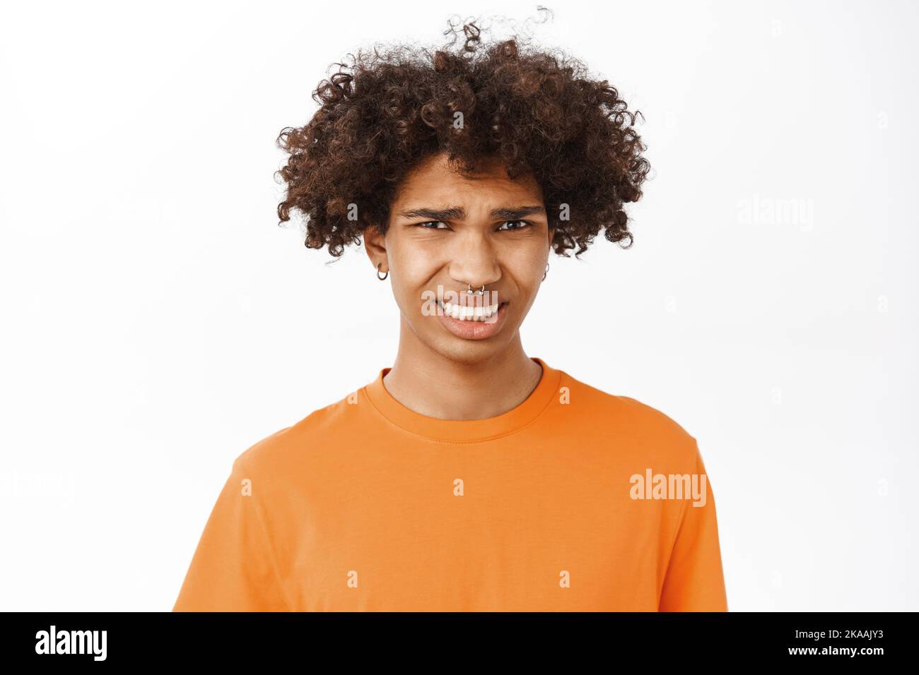 Yikes. Close up curly guy looking disgusted and upset, cringe over ...