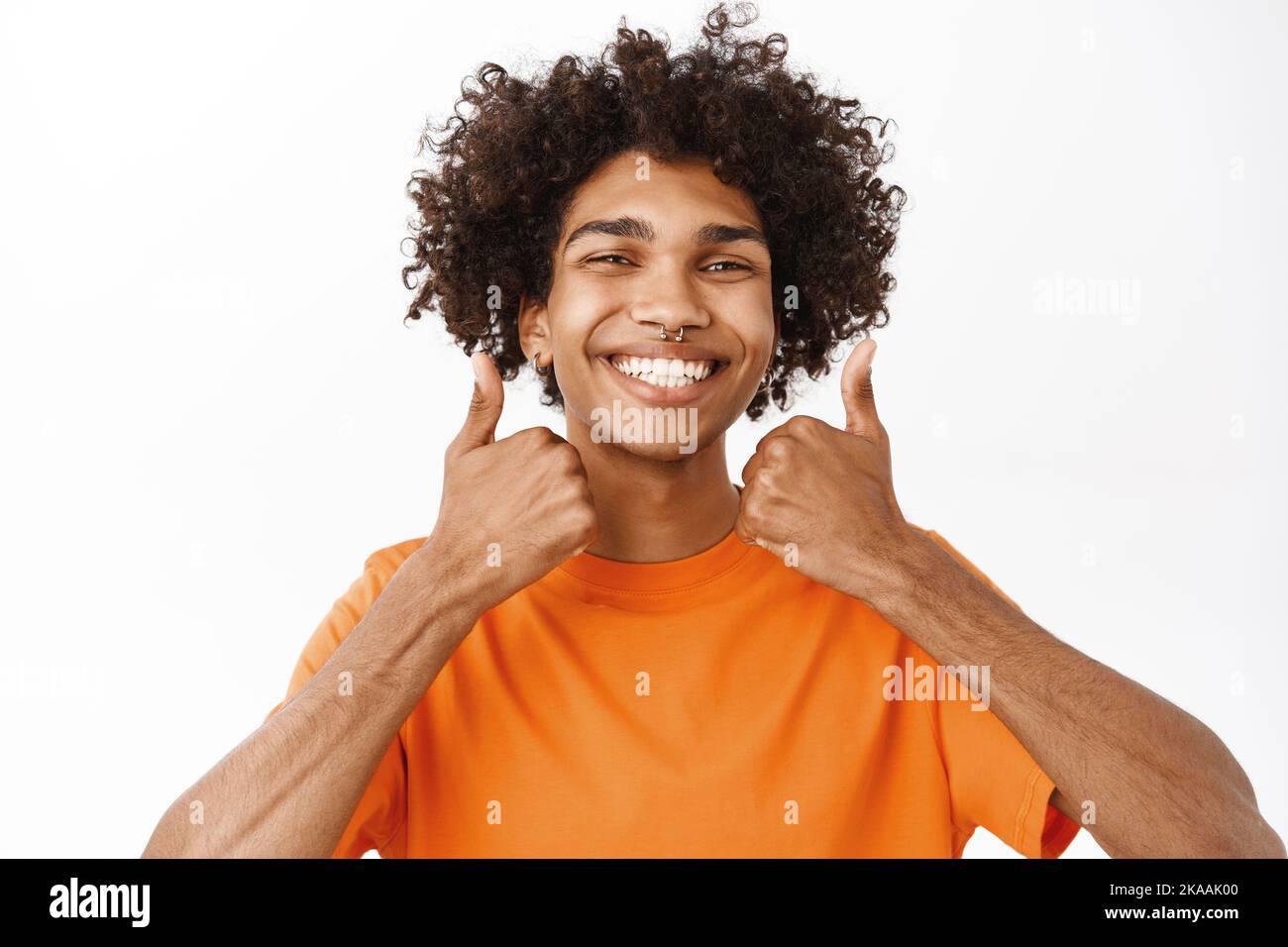 Close up portrait of enthusiastic young man showing thumbs up near his ...