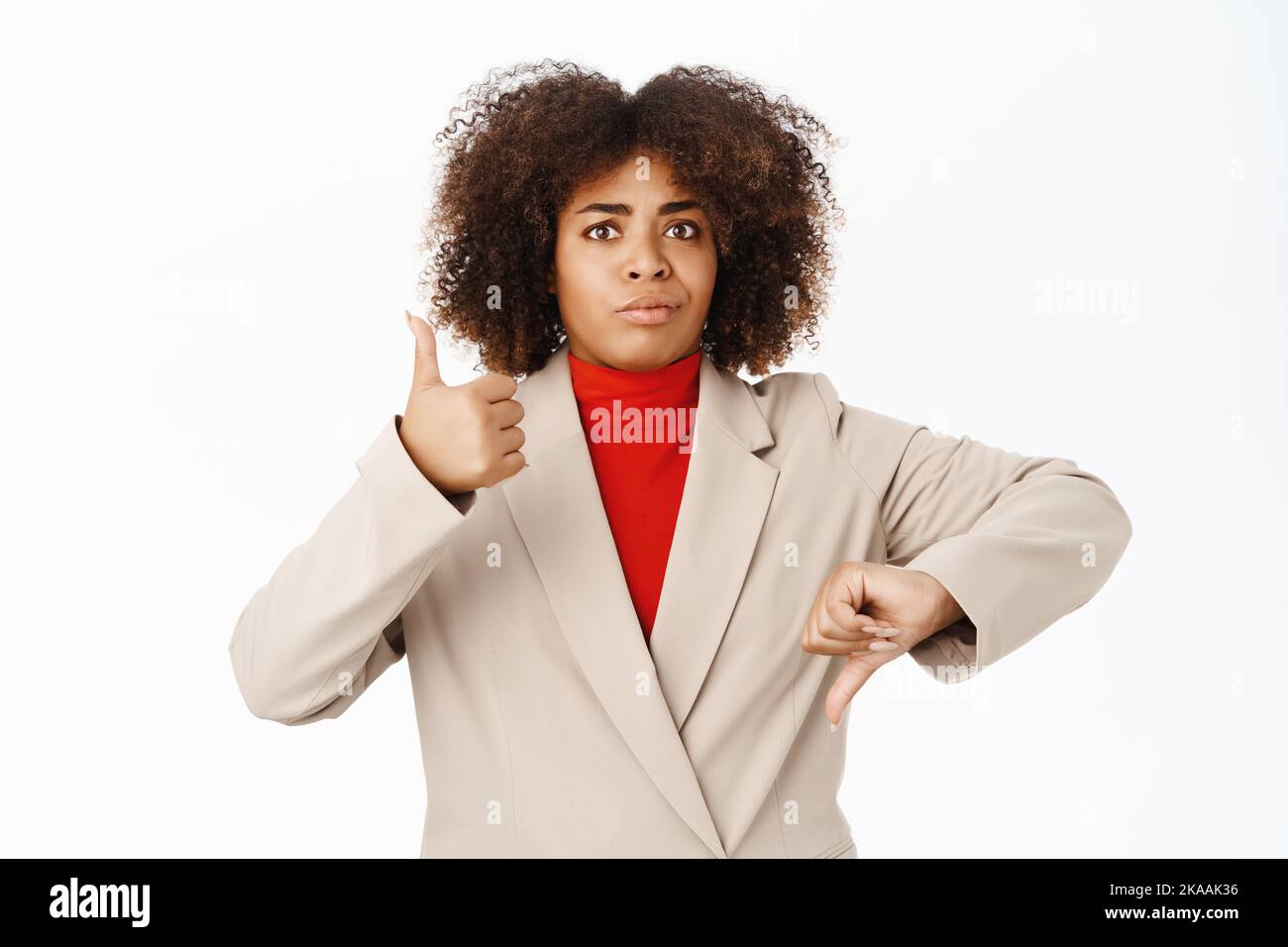 Uncertain choice. Confused african american businesswoman shows thumbs ...