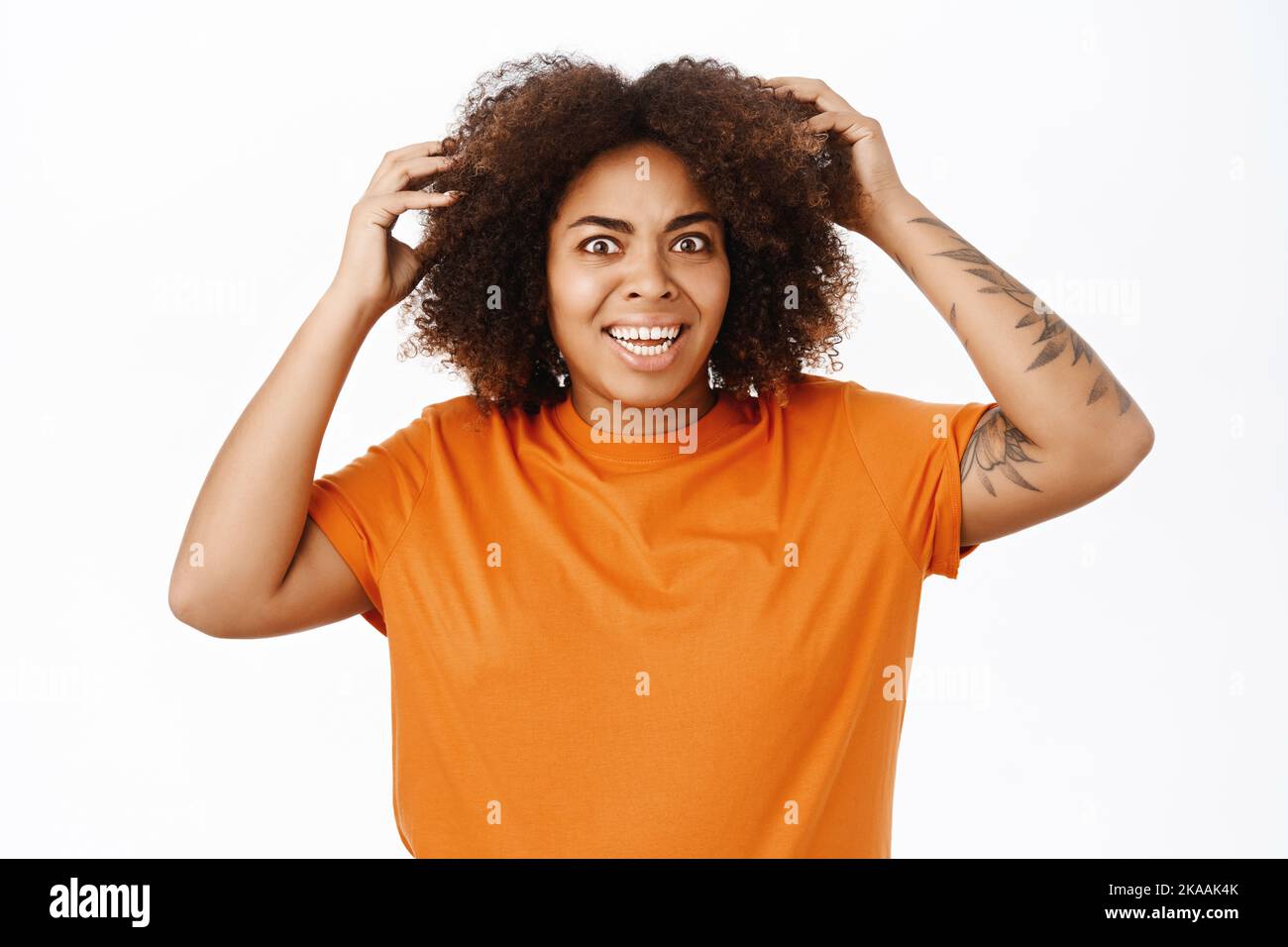 Freaked out african american girl with crazy eyes, touching her curly ...
