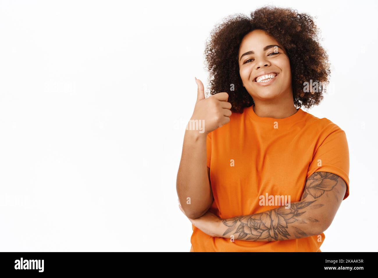 Portrait of smiling african american woman shows thumbs up, nod in ...