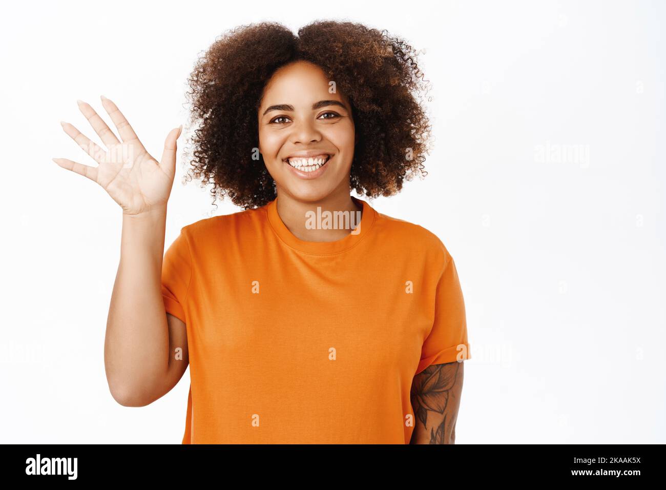 Friendly smiling african american woman saying hello, waving hand at ...