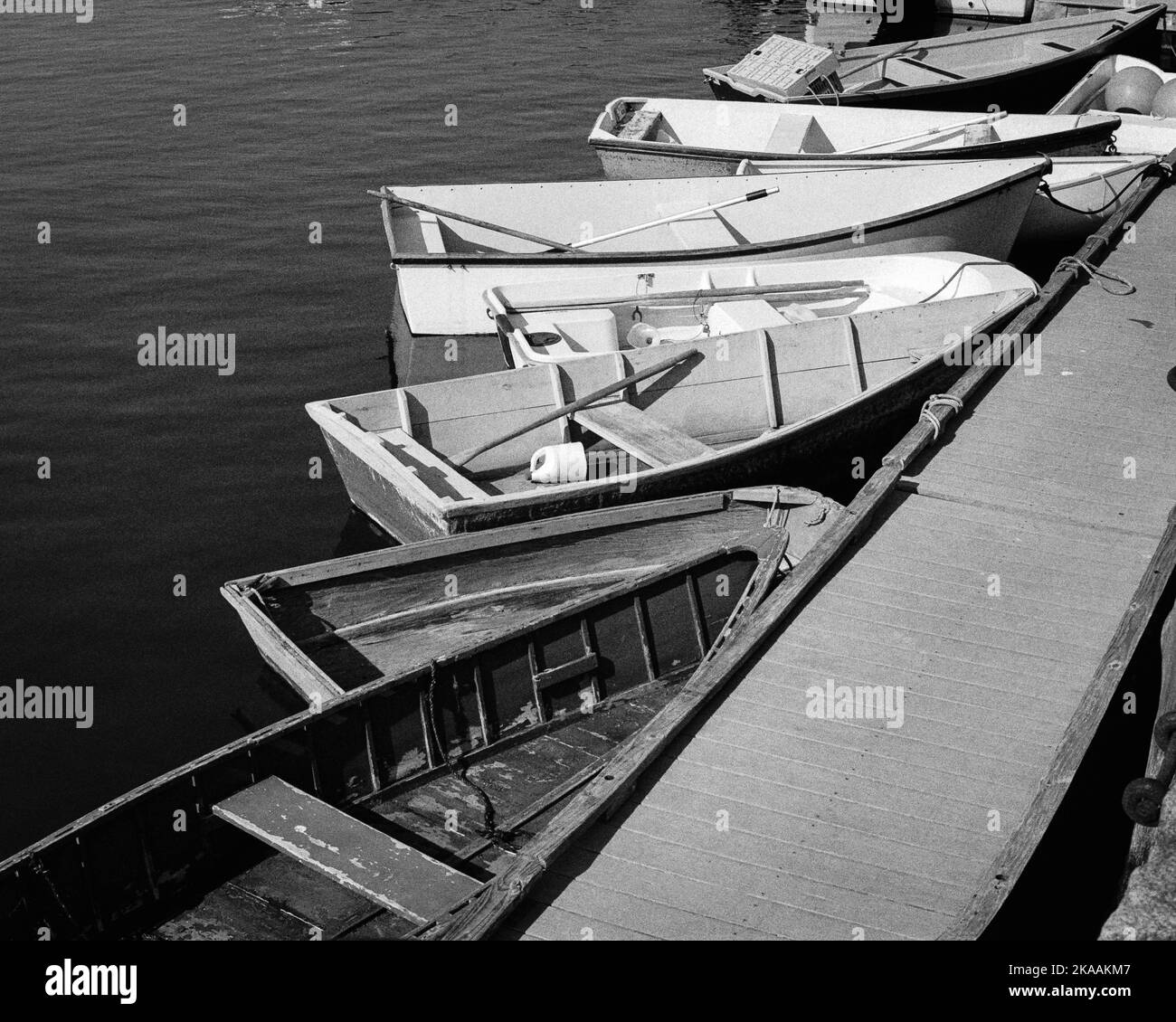 A row of wooden row boats docked in the harbor at Rockport ...
