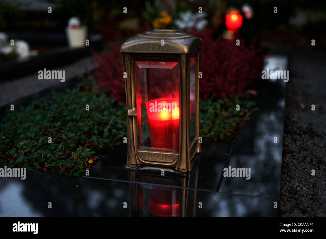 metal grave lantern with burning candle on a grave at dusk Stock Photo - Alamy