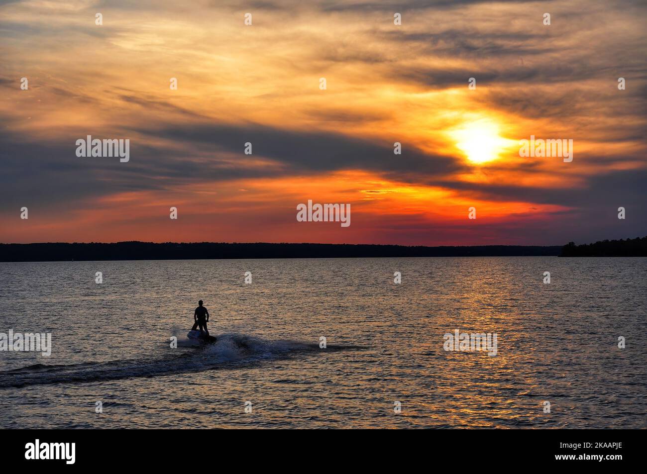 Jet skier driving off into the sunset on a summer night Stock Photo - Alamy