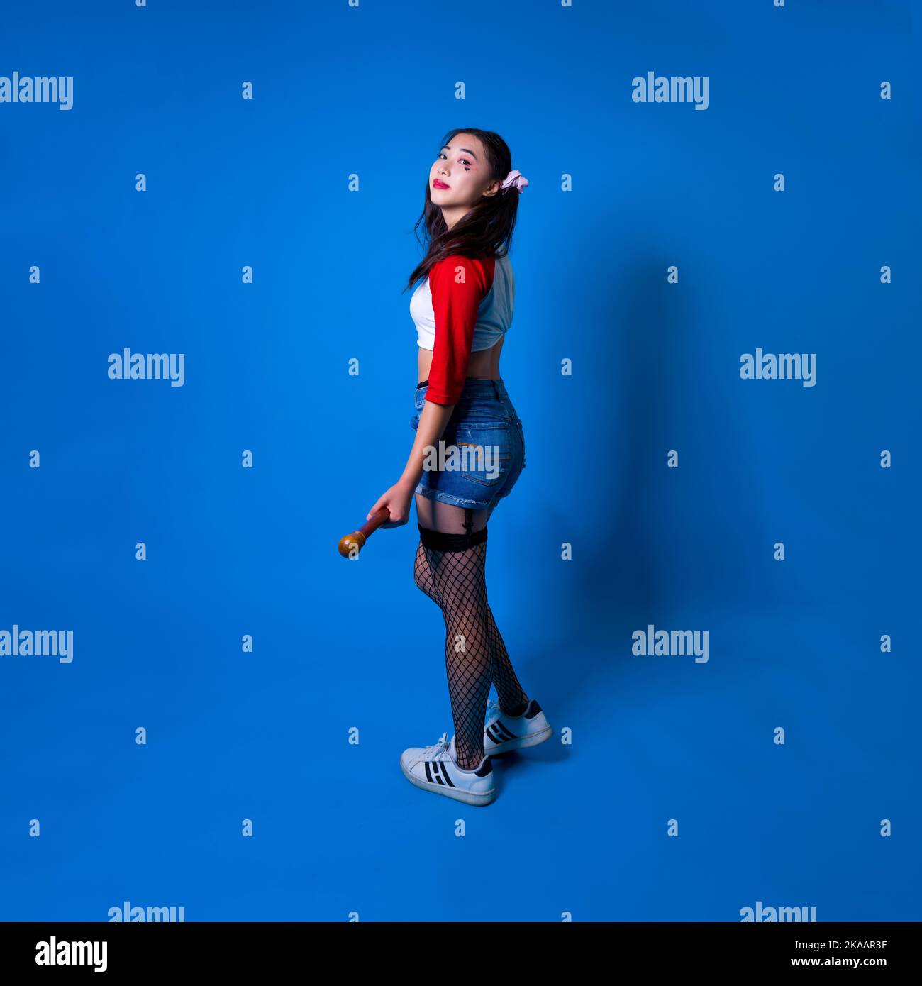 Young Woman in Harlequin Costume Standing in Front of Blue Background ...