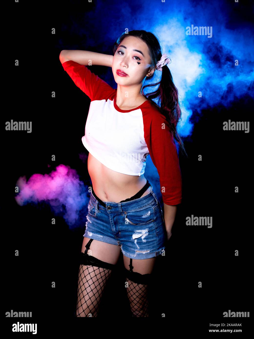 Young Woman in Harlequin Costume Standing in Front of Brightly Lit Fog ...