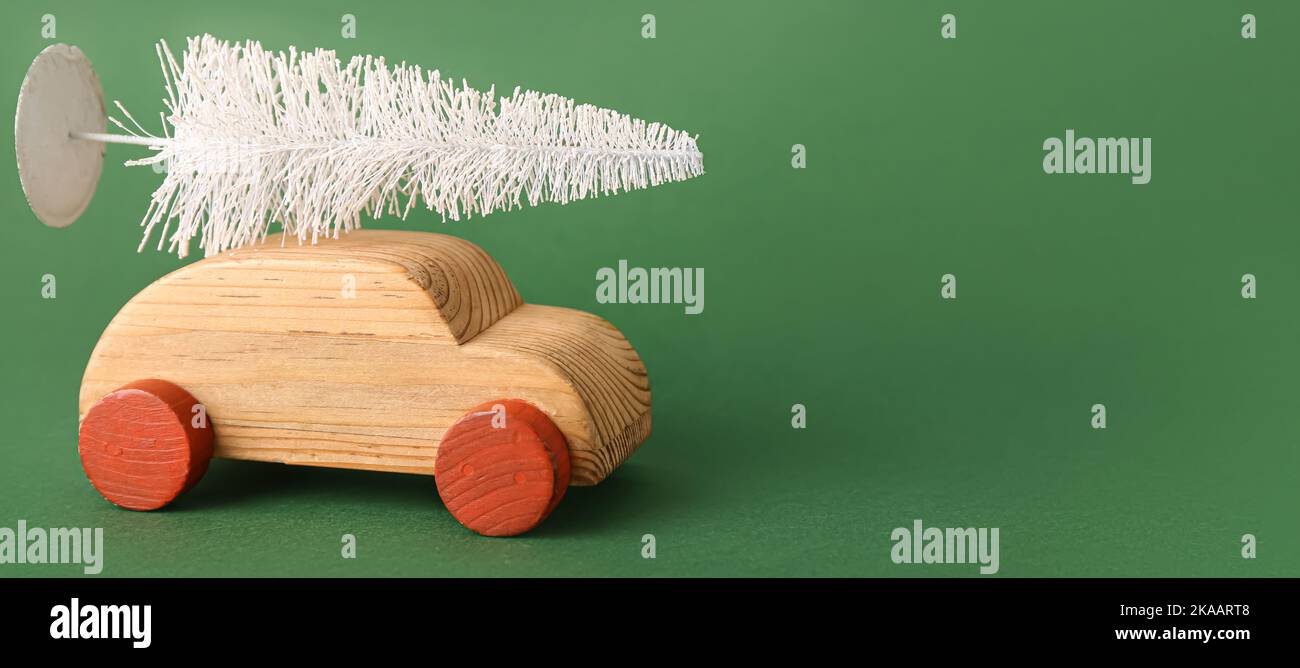 Toy car with small Christmas tree on green background Stock Photo - Alamy