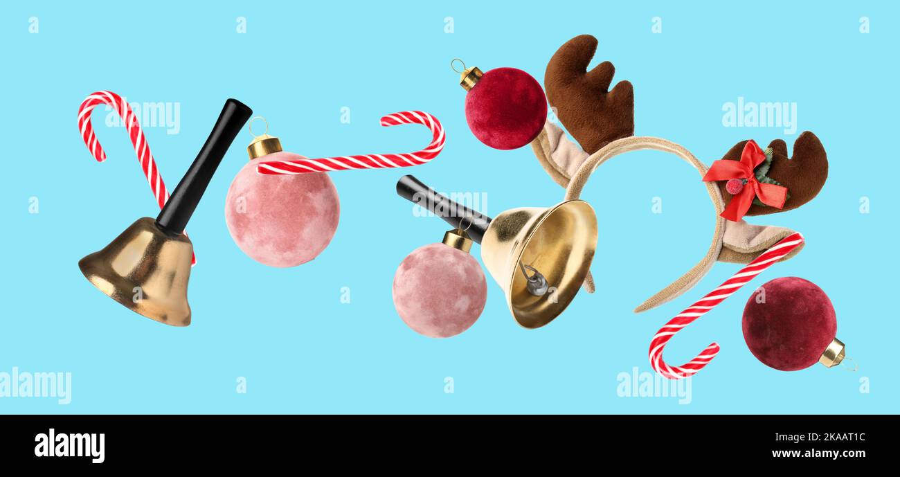 Flying Christmas bells and decor on light blue background Stock Photo ...