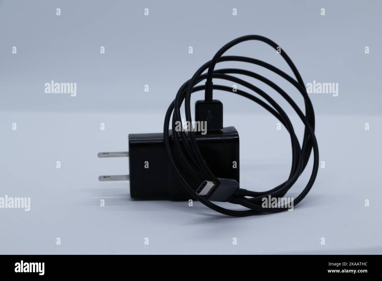 Black charger and cable on white background Stock Photo - Alamy