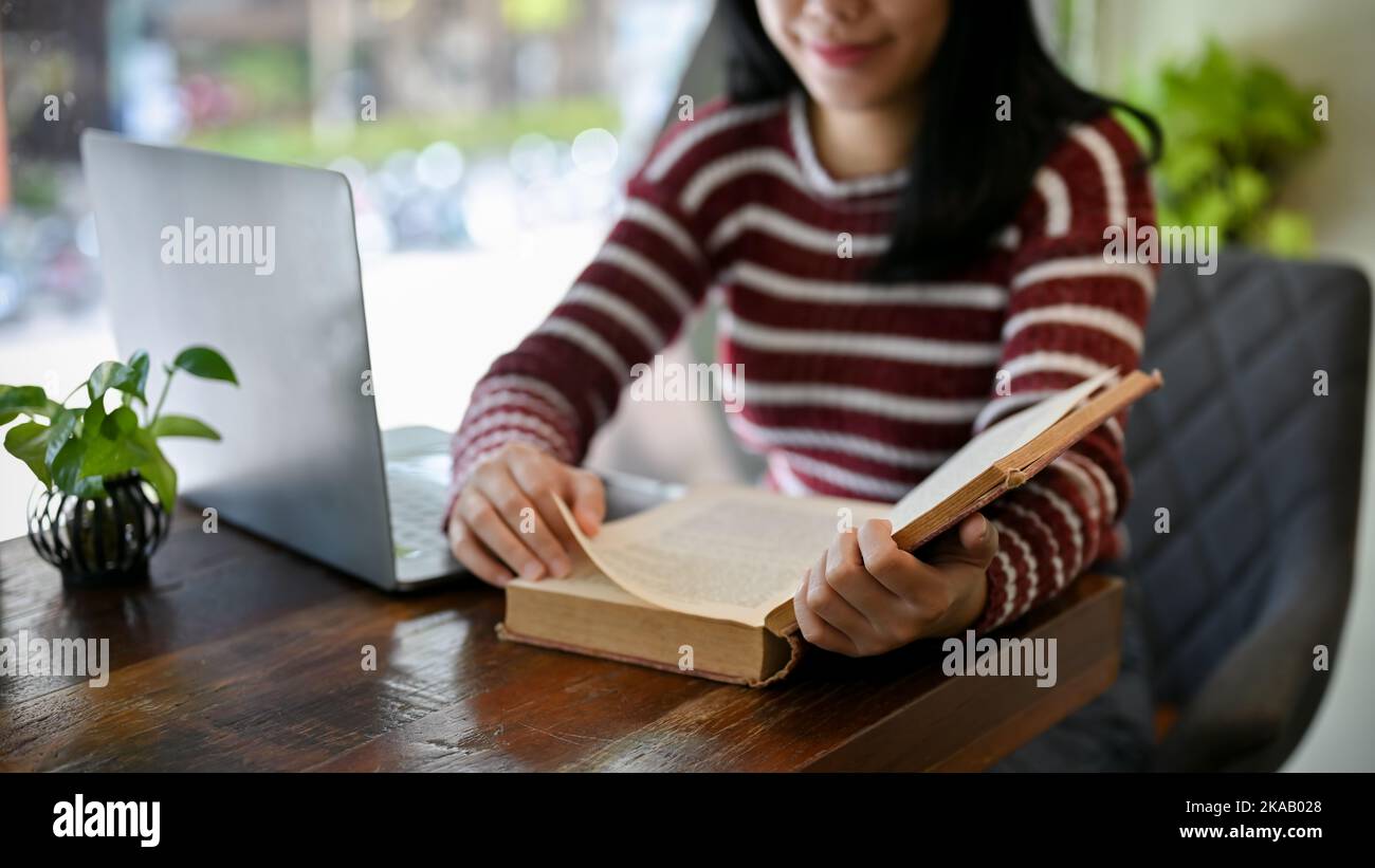 Charming and happy young Asian female college student researching ...