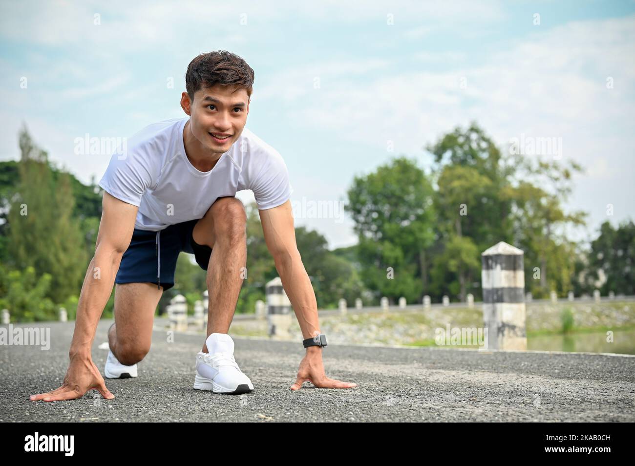 Handsome determined athletic young Asian man in sportswear preparing to ...