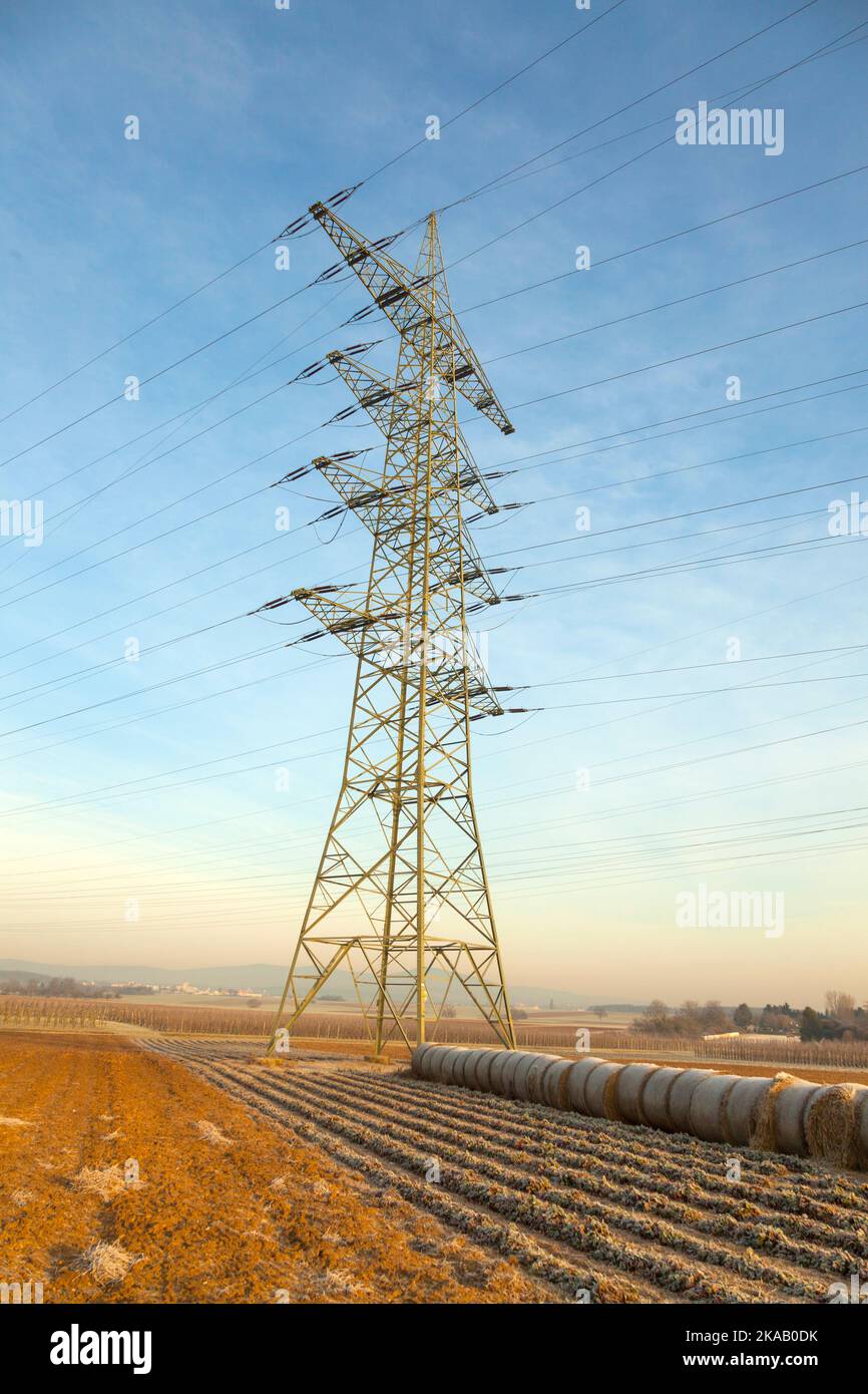 electrical tower in rural landscape with bale of straw Stock Photo - Alamy