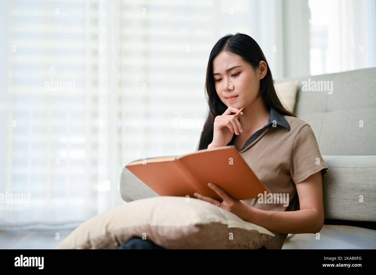 Beautiful and smart young Asian female college student concentrating on ...