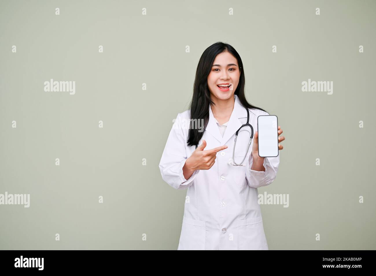 Beautiful Asian female doctor in uniform pointing finger at a ...