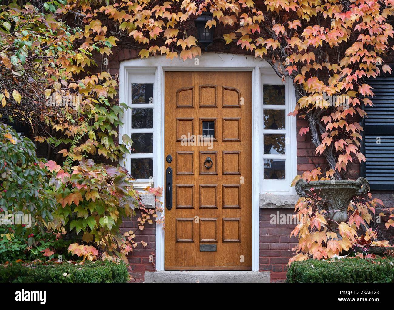 Front door of old brick house surrounded by ivy in autumn Stock Photo ...