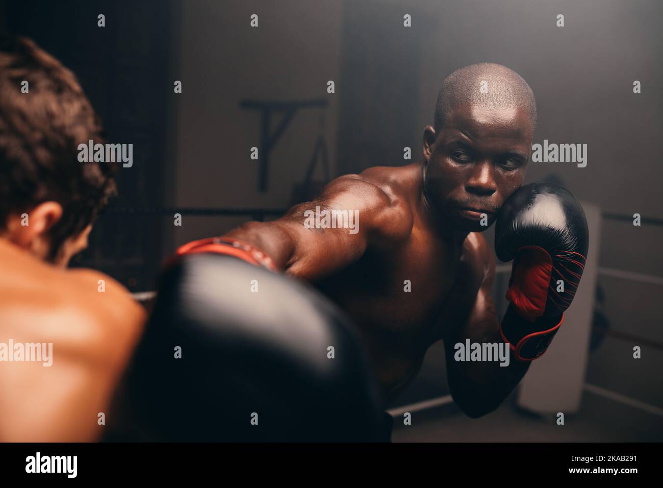 Black boxer at striking his opponent with gloved fists during a match ...