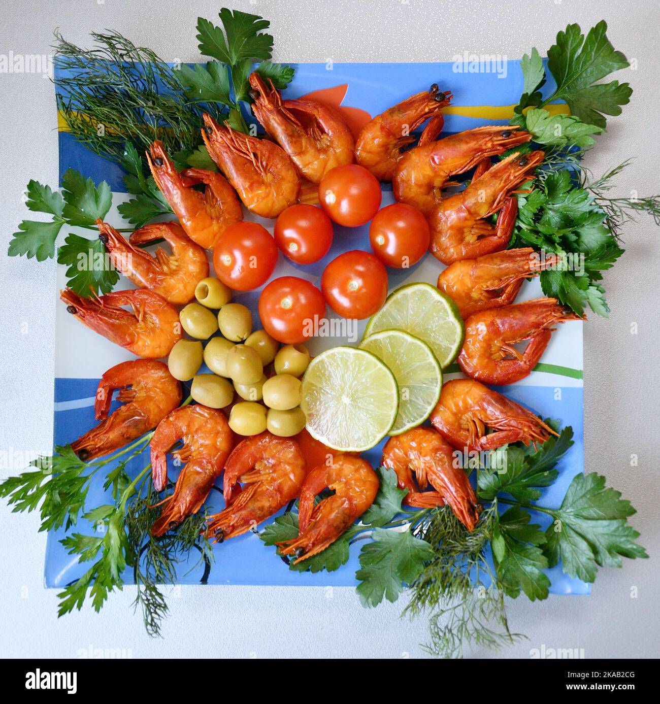 Cooked shrimp with fresh herbs, olives, lime and tomatoes Stock Photo ...