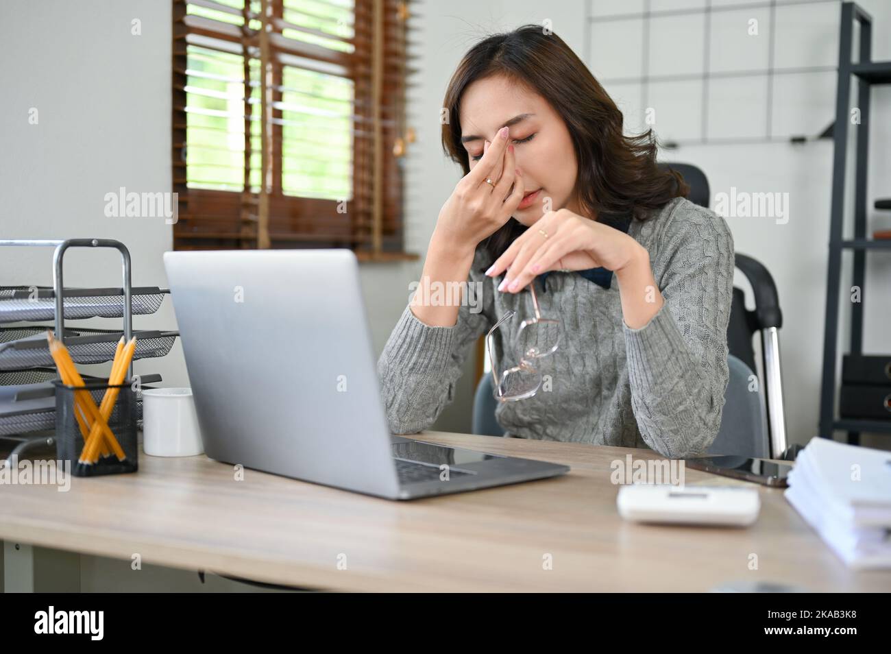 Tired overworked and stressed millennial Asian businesswoman or female ...